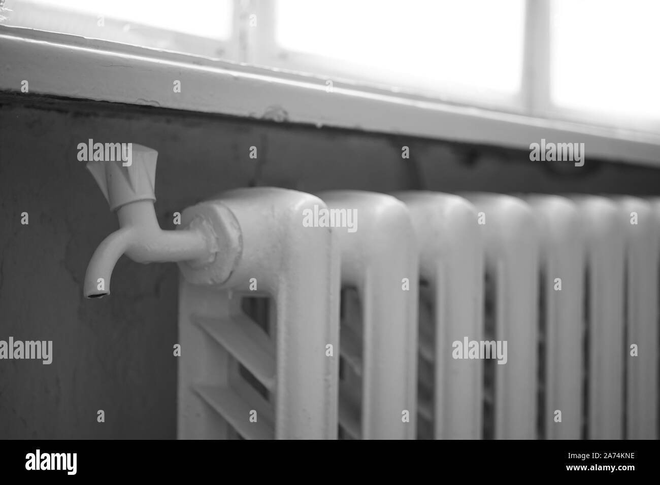 White iron radiator with tap, winter window, central heating in the ...