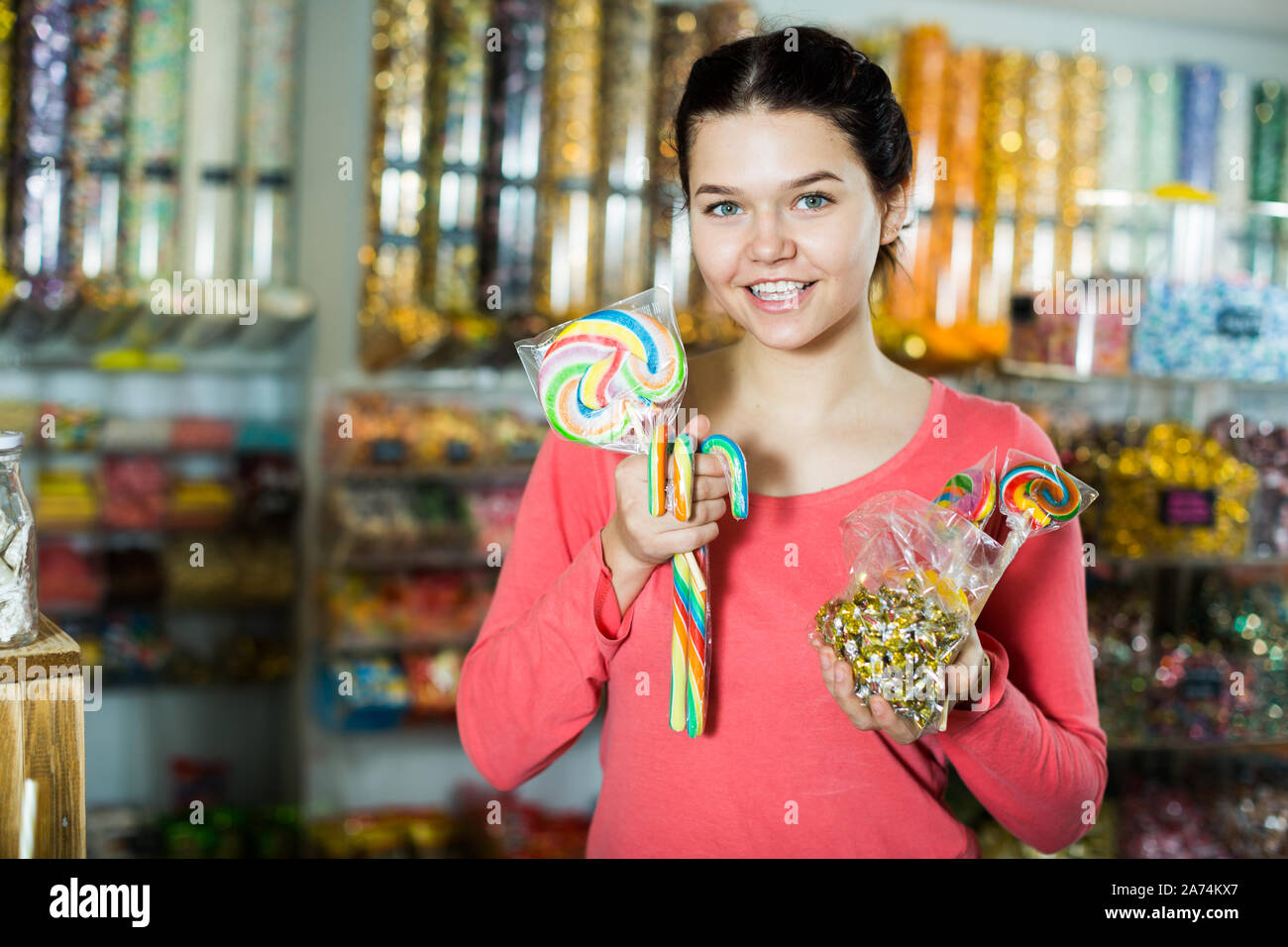Happy brunette girl buying candies at shop Stock Photo - Alamy