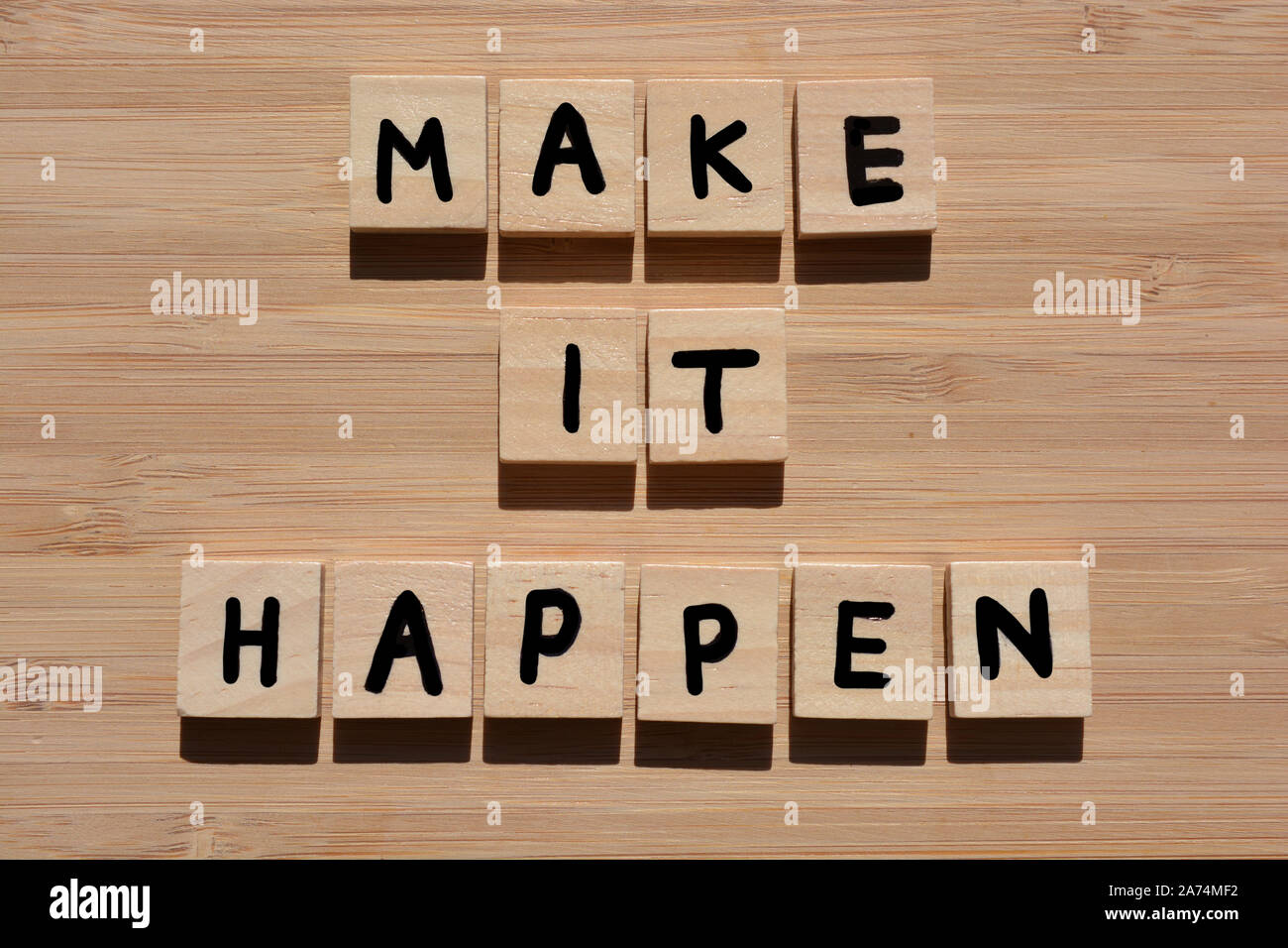 Make it Happen. Motivational words in 3d wooden alphabet letters on a ...