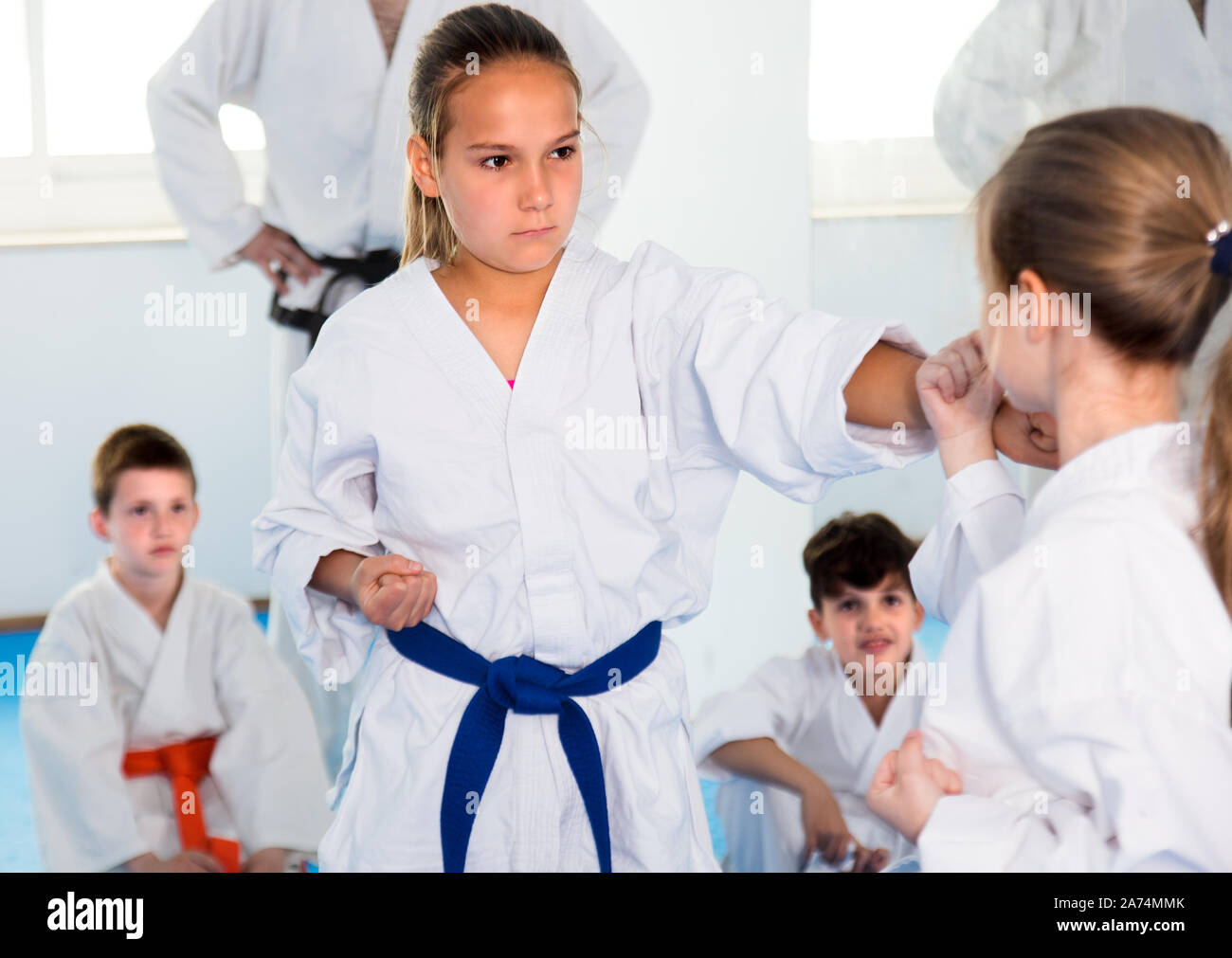 Young female children are trying in sparring to use new moves at karate ...