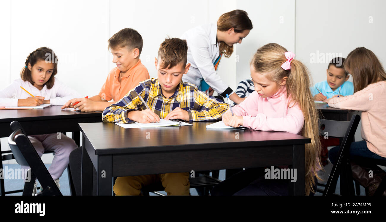 Cheerful professor and elementary age children at classroom Stock Photo ...