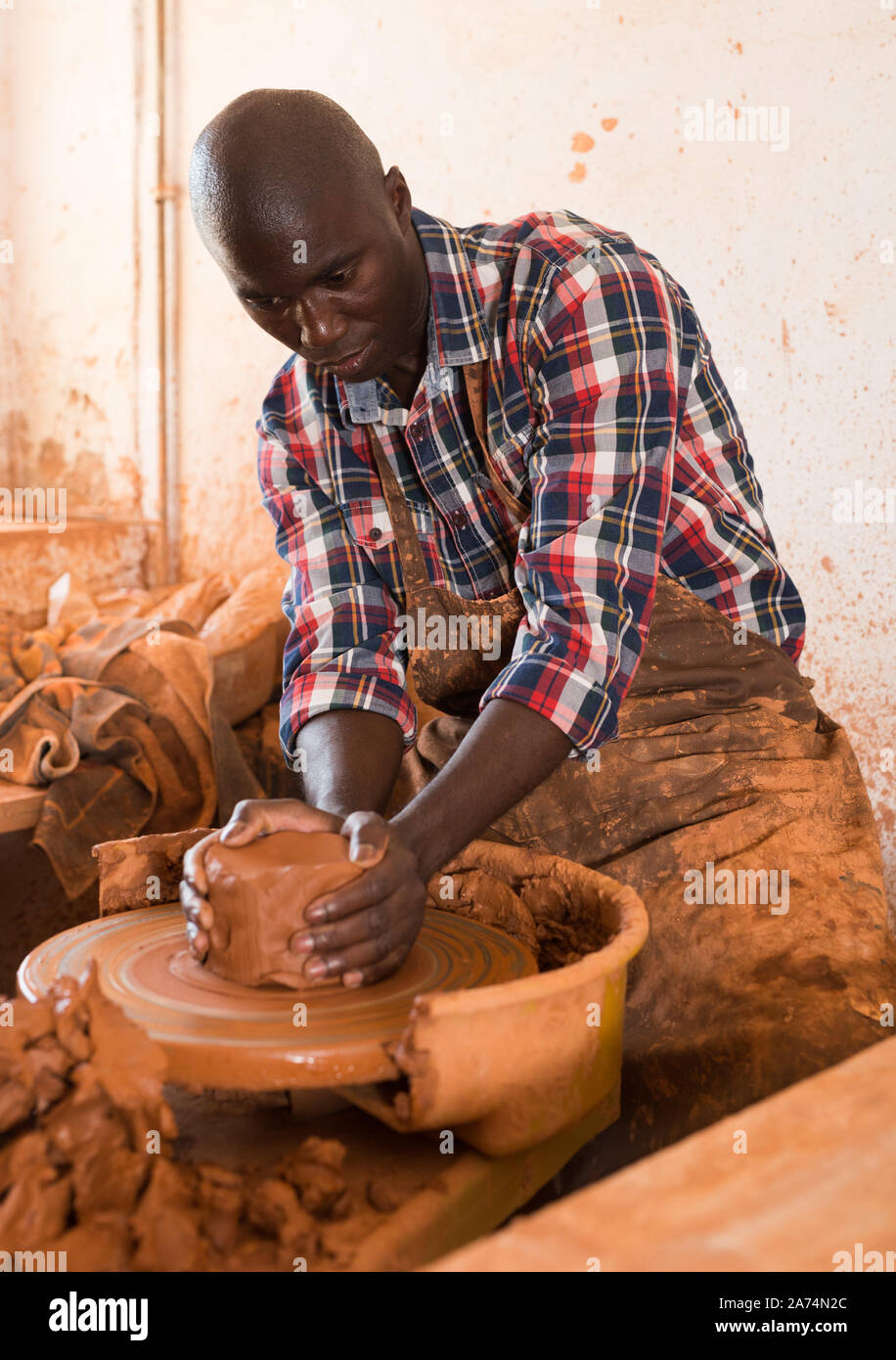 Professional male potter making bowl on potters wheel in pottery studio ...