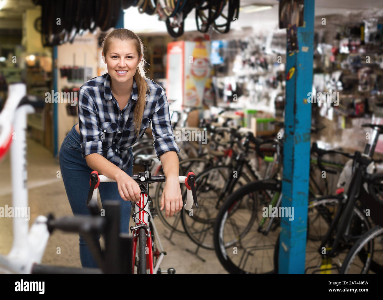 Portrait of female is standing with bicycle in store Stock Photo - Alamy