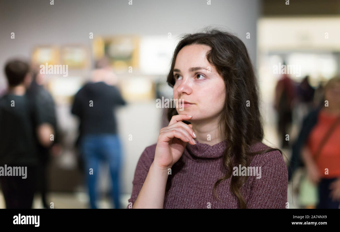 Positive woman visiting museum and thinking about arts indoors Stock ...
