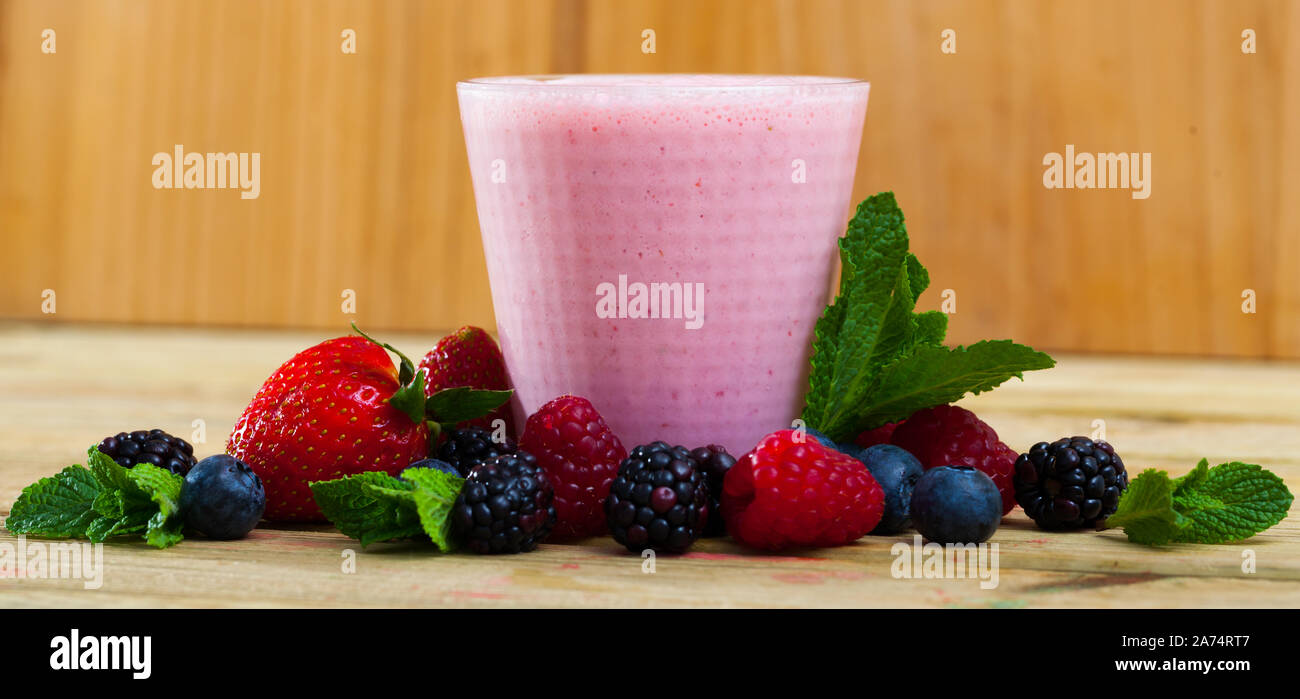 Healthy vitamin milkshake with mix of ripe berries and mint leaves ...