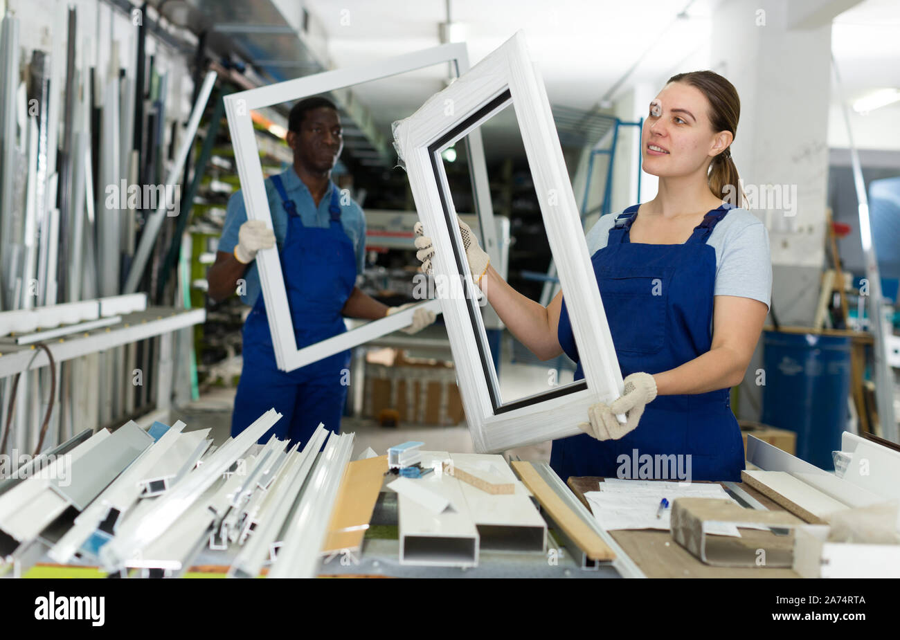 Female master is working with window frame in the window workshop Stock ...