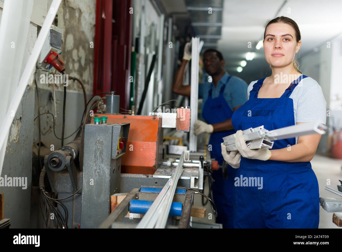 Young woman master is construction modern windows near machine in the ...