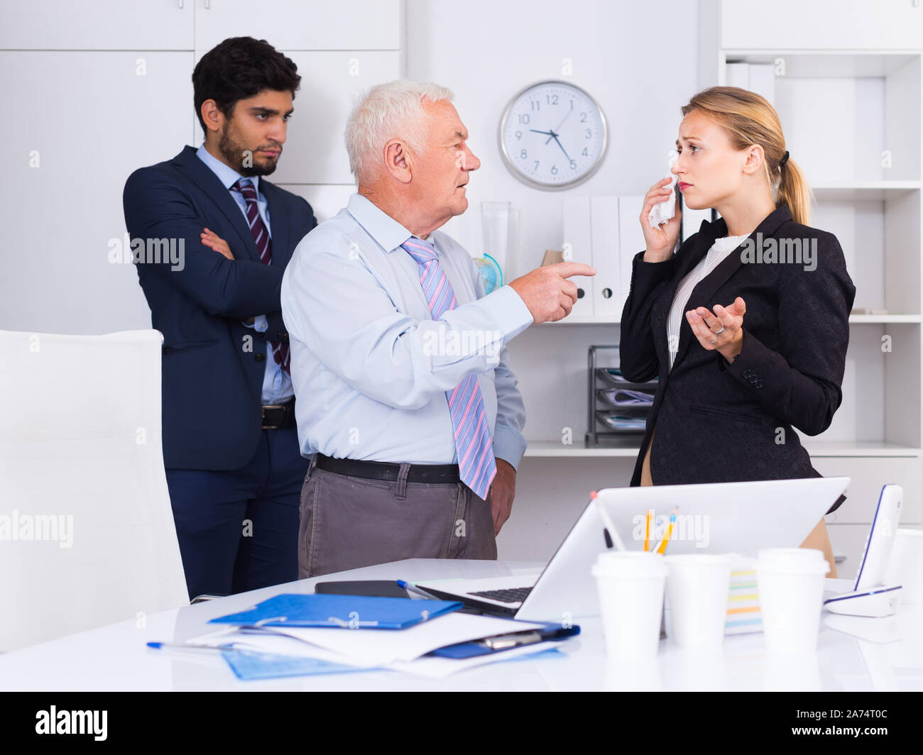 Mature boss is chastising employees because of uncompleted work in the ...