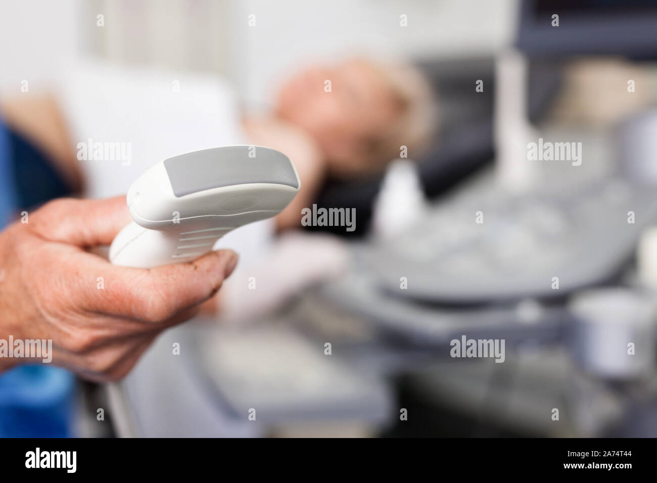 Male doctor holding ultrasonic probe in hand, ultrasound machine and ...