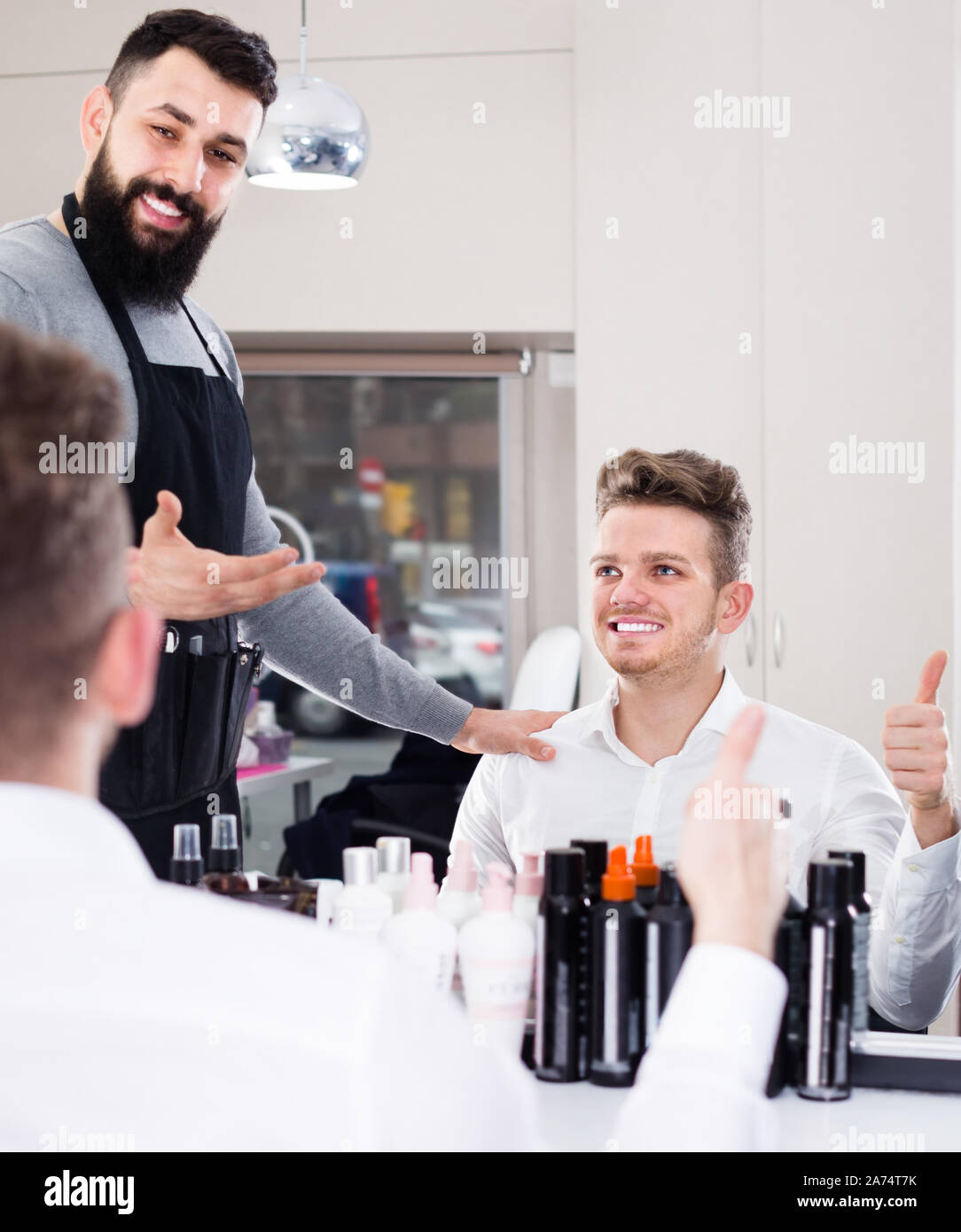 professional guy stylist demonstrating final fashionable haircut to ...