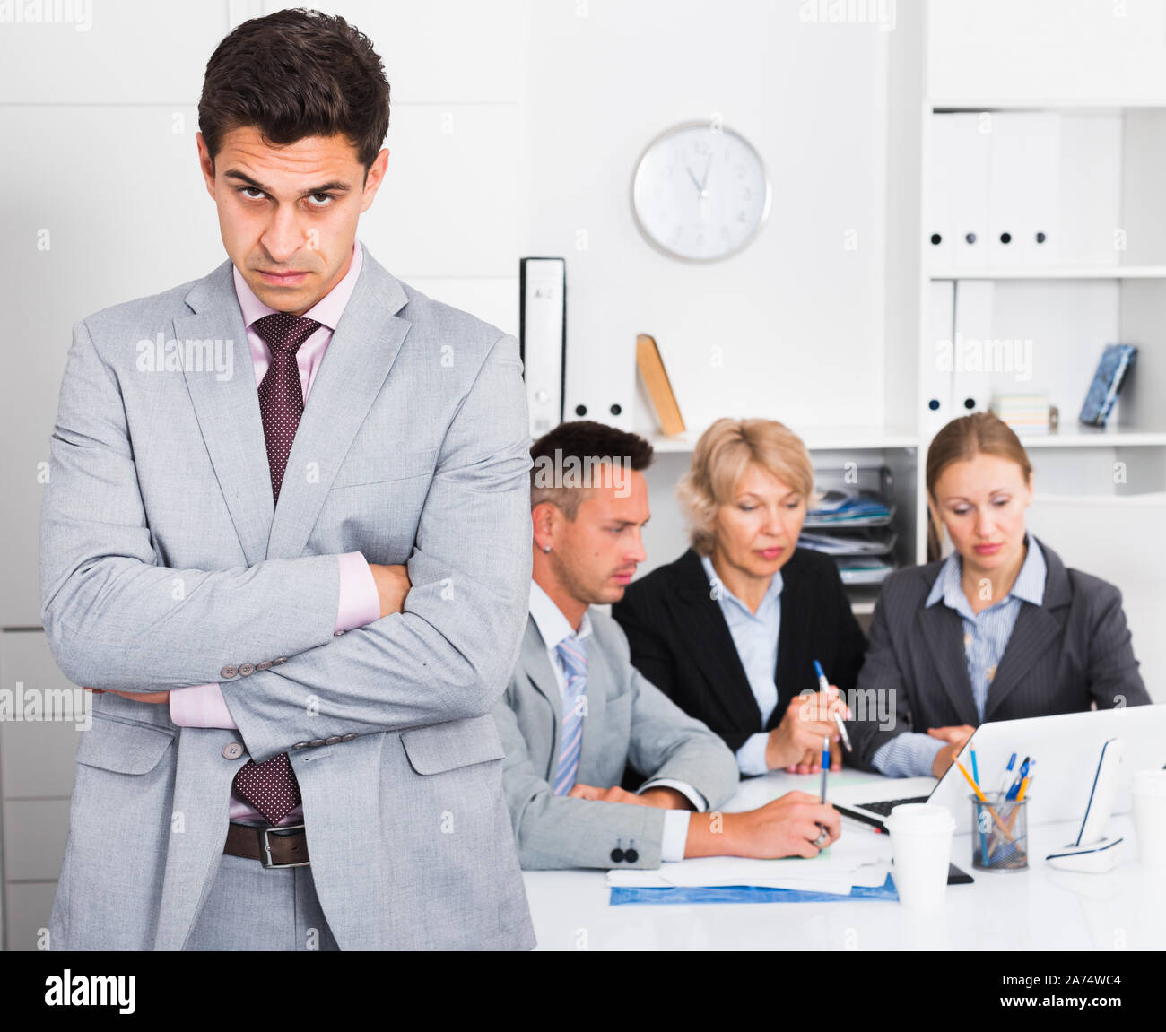 Angry manager standing in office dissatisfied with teamwork of ...