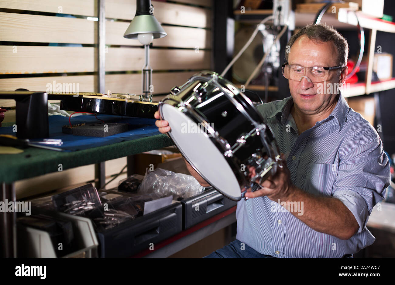 Senior male music master is repairing drums in his workshop Stock Photo ...