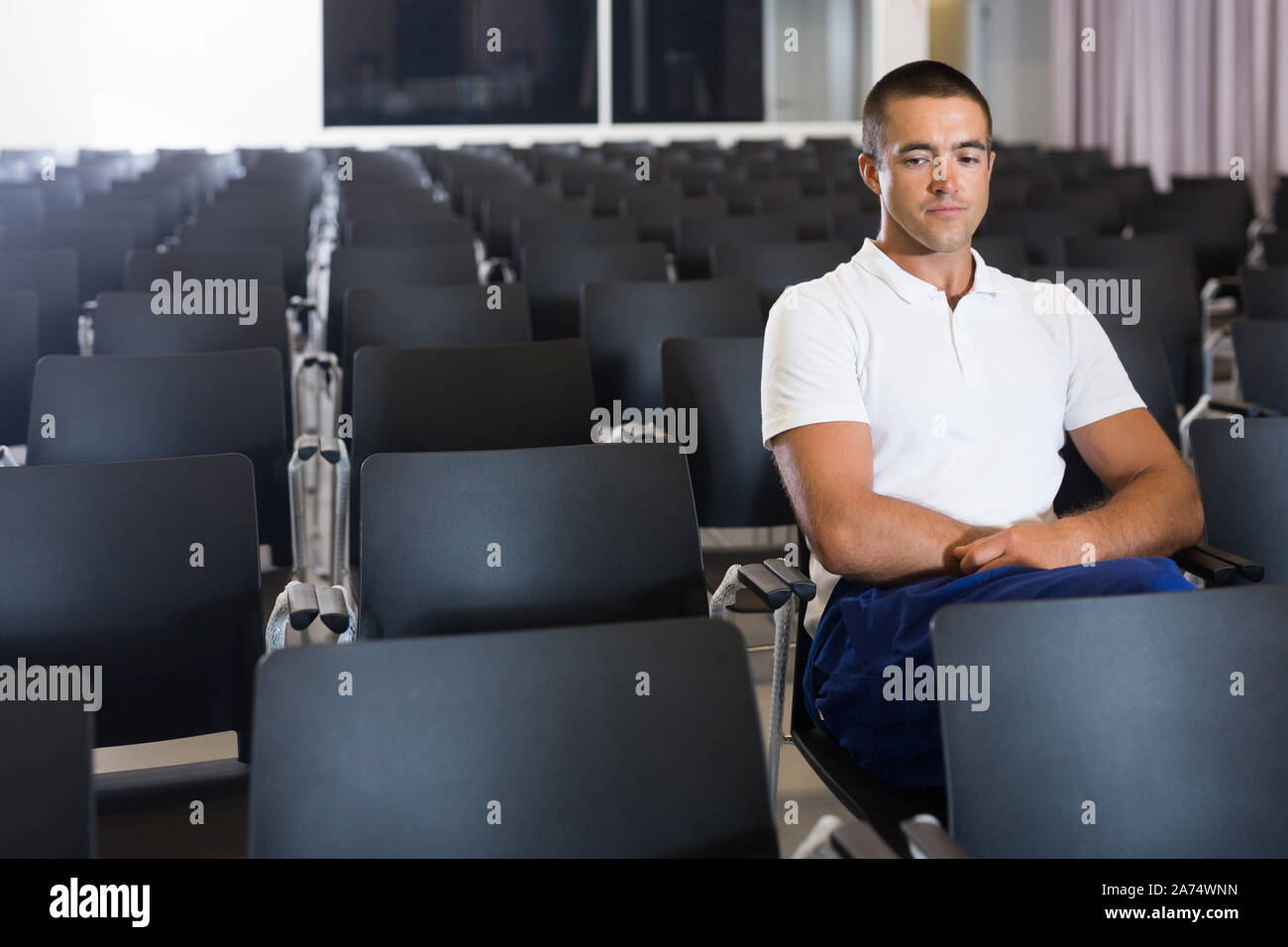 Portrait of young man sitting in empty conference room Stock Photo - Alamy
