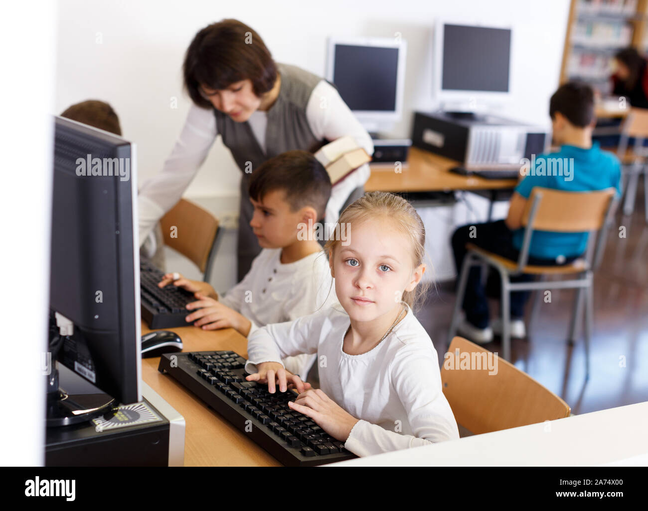 Portrait of serious tween girl during lesson in computer room of school ...