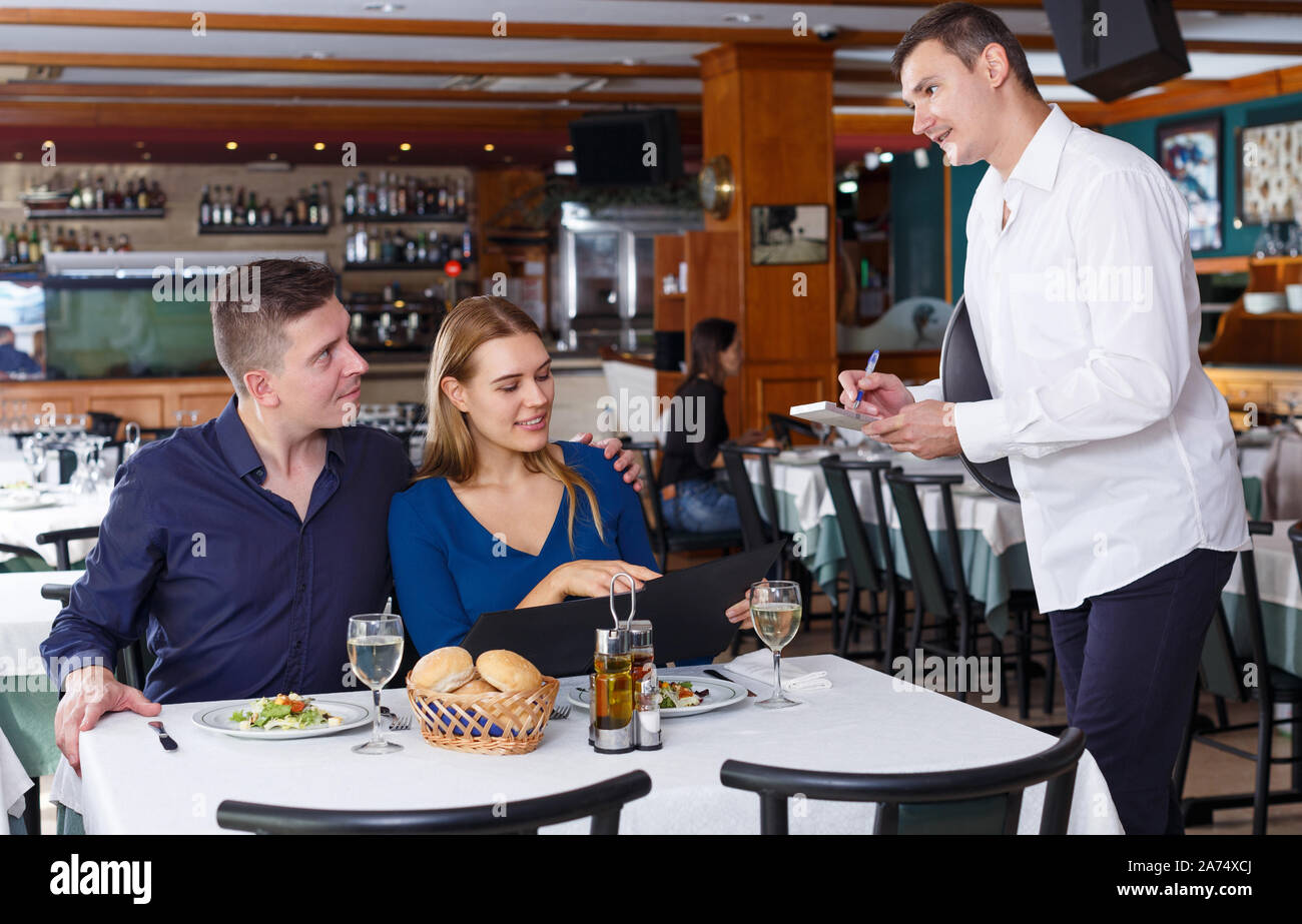 Cheerful man and woman with menu ordering food in restaurant Stock ...