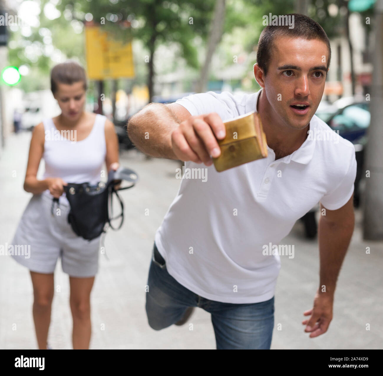 Male thief stealing purse from scared woman on street Stock Photo - Alamy