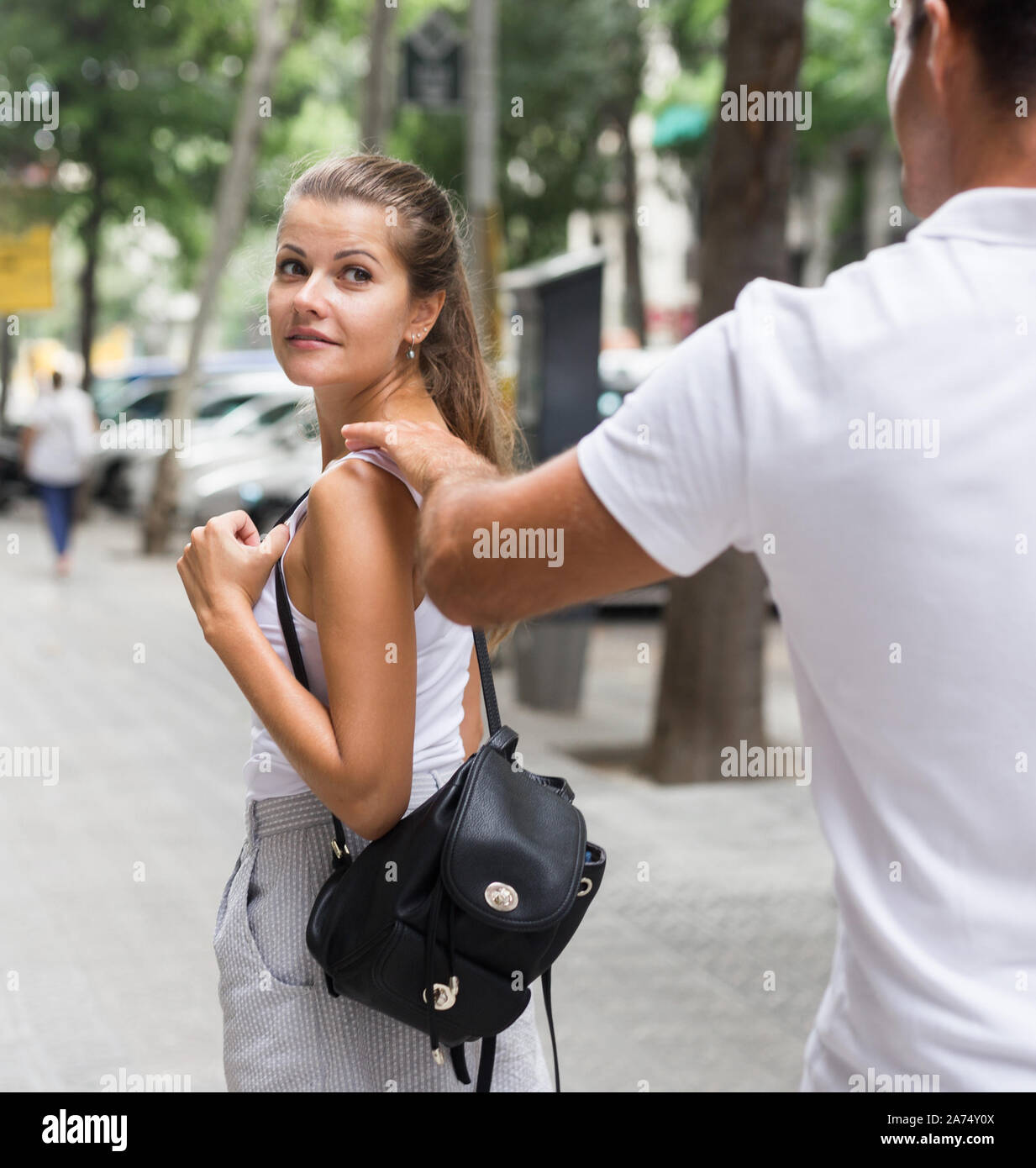 Girl turning around because man touching her shoulder on street Stock ...