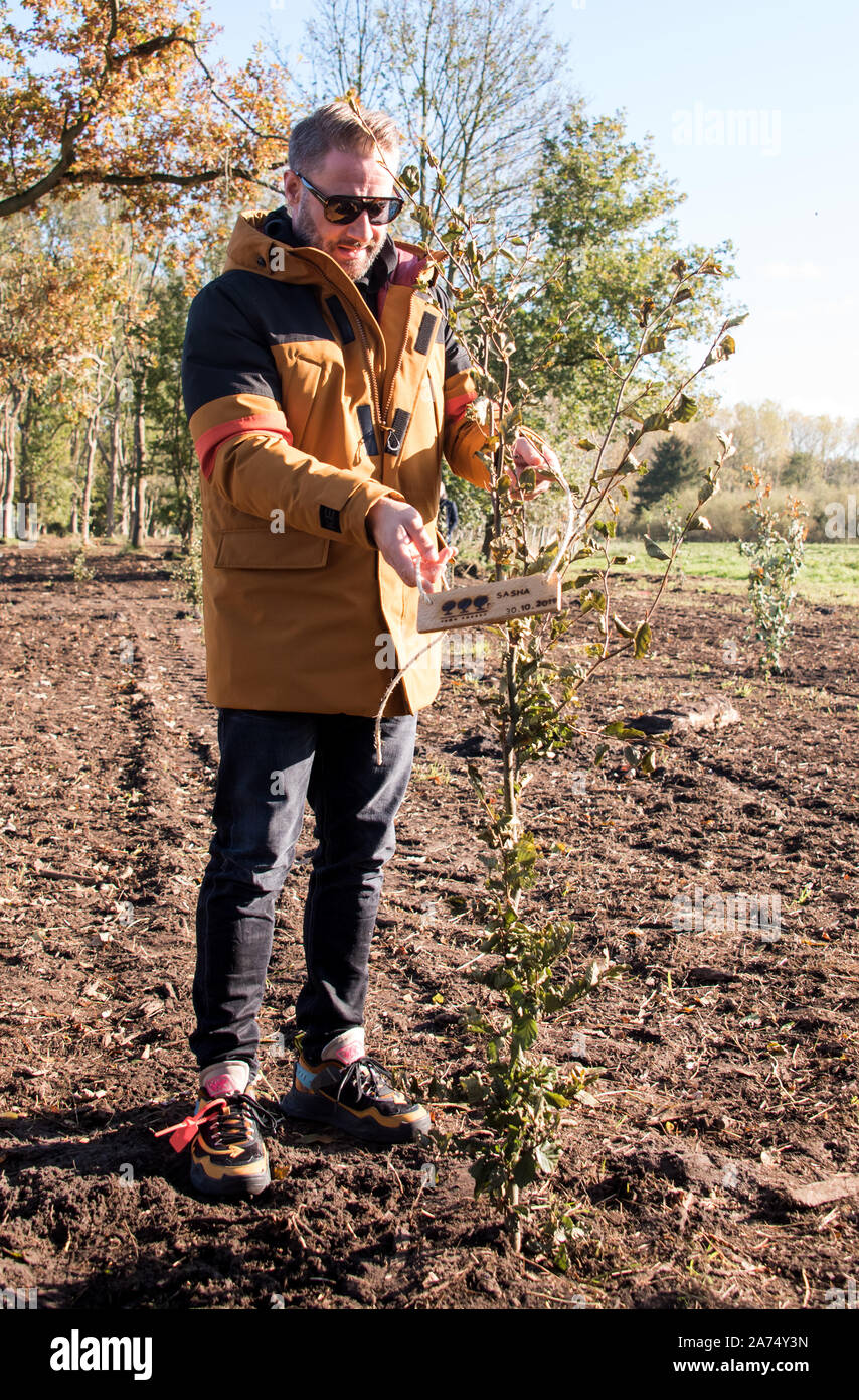 30 October 2019, Hamburg: Sasha, musician hangs a name tag on a tree in ...