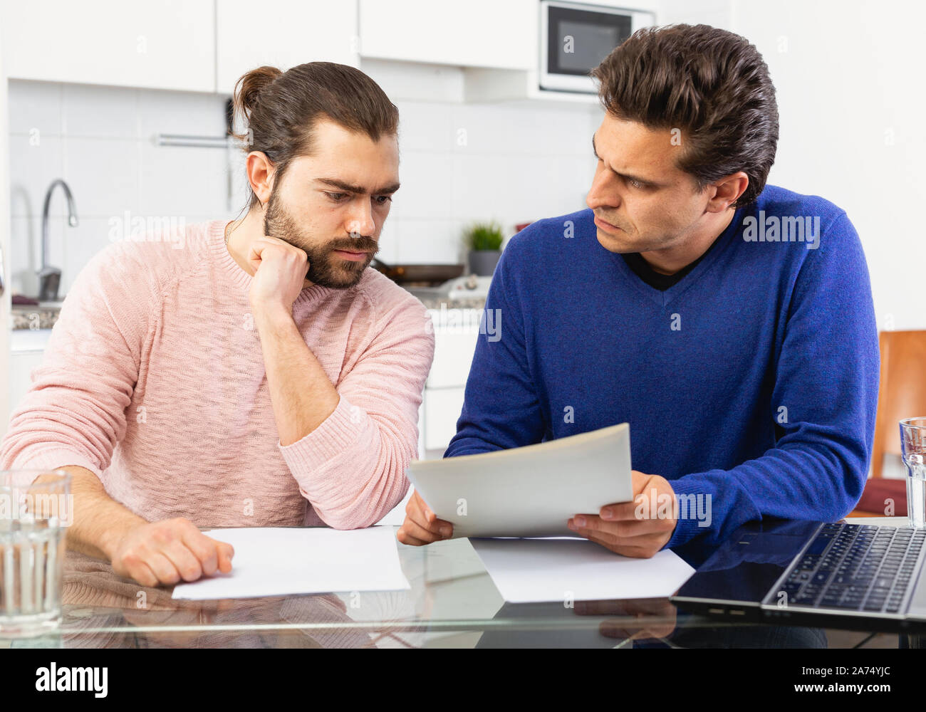 Man having problems with some documents; worriedly discussing with ...