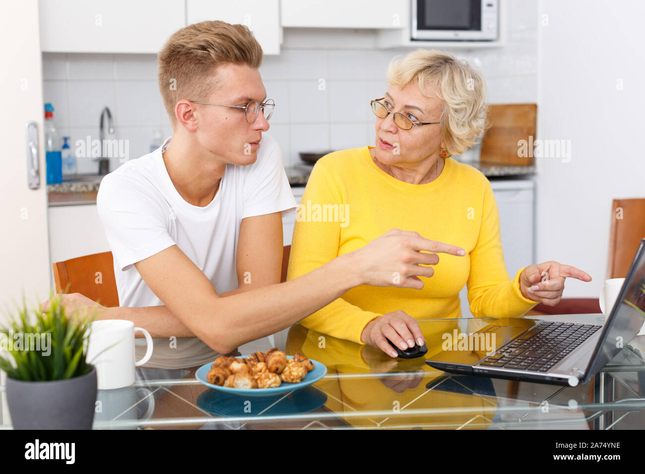 Child helping elderly with laptop hi-res stock photography and images ...