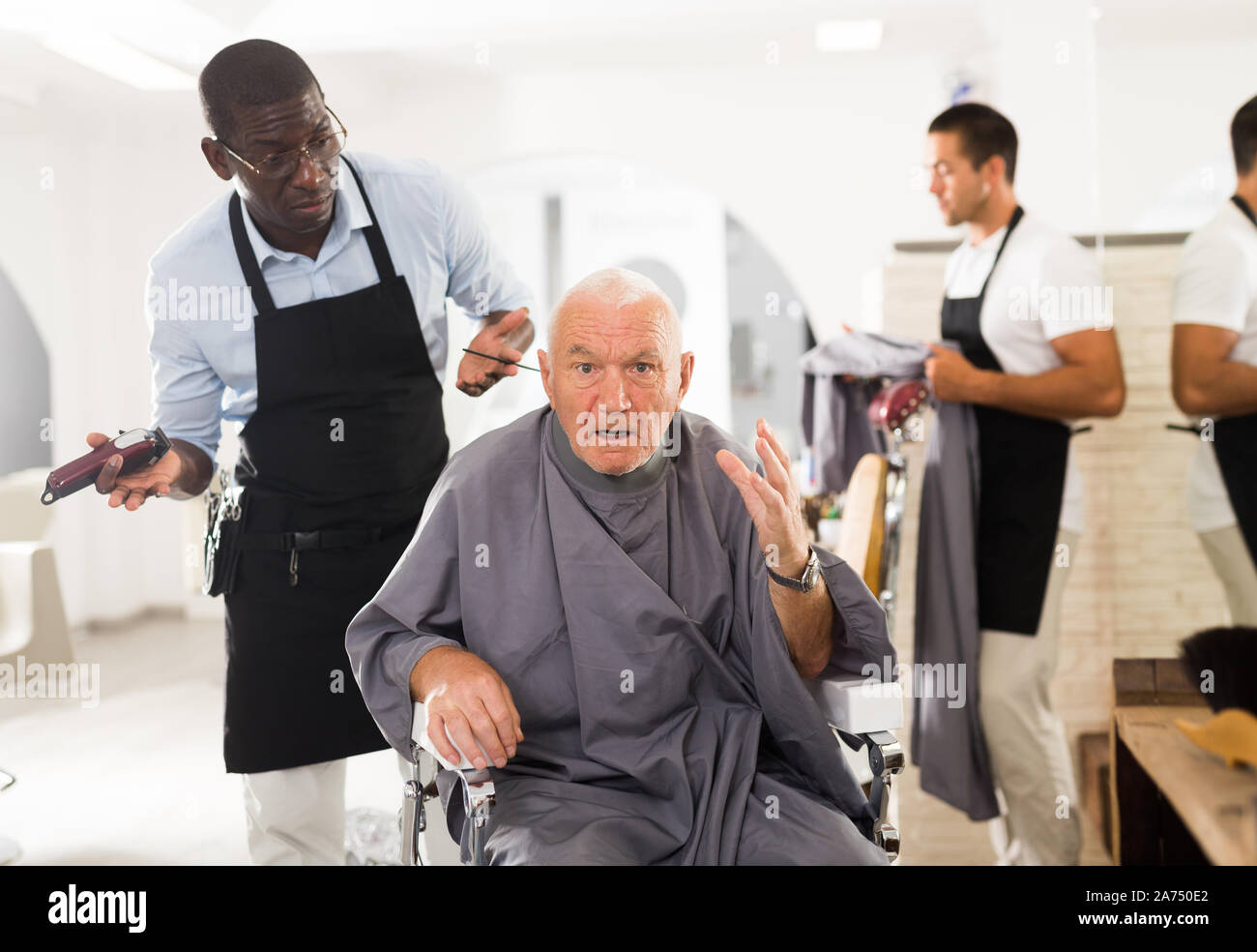Portrait of upset dazed aged man sitting in barber chair with confused ...