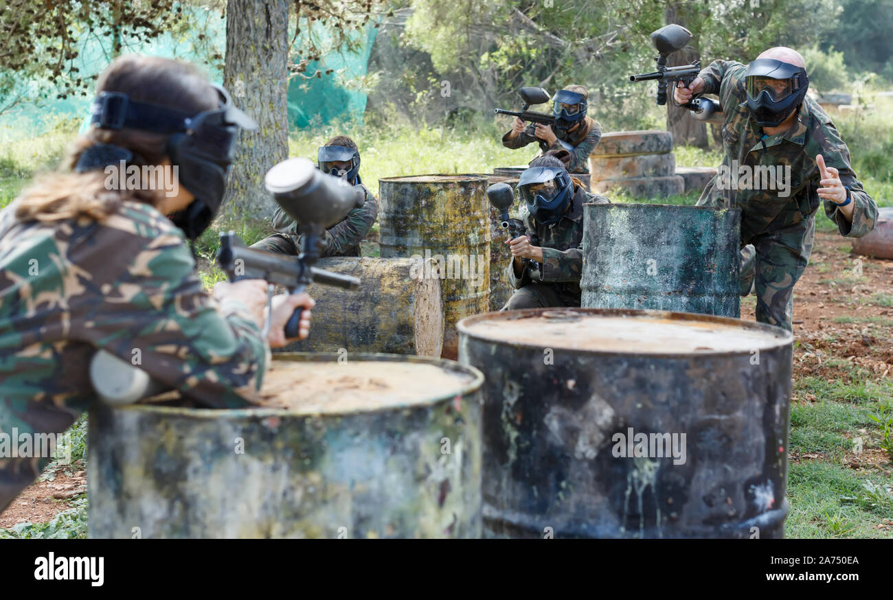 gambling teams facing on battlefield in outdoor paintball arena during ...