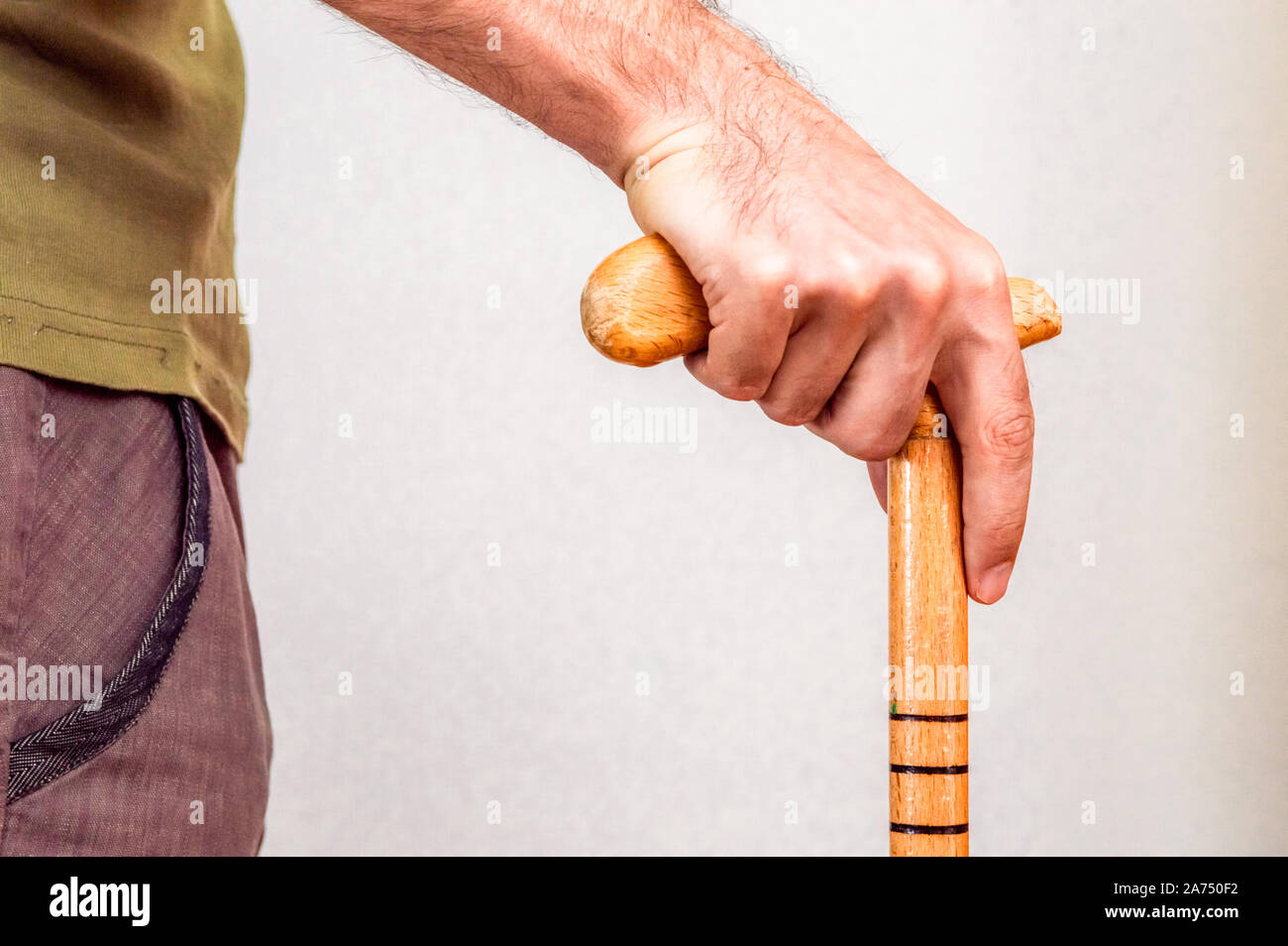 Close up of male hand with a walking stick on white background ...