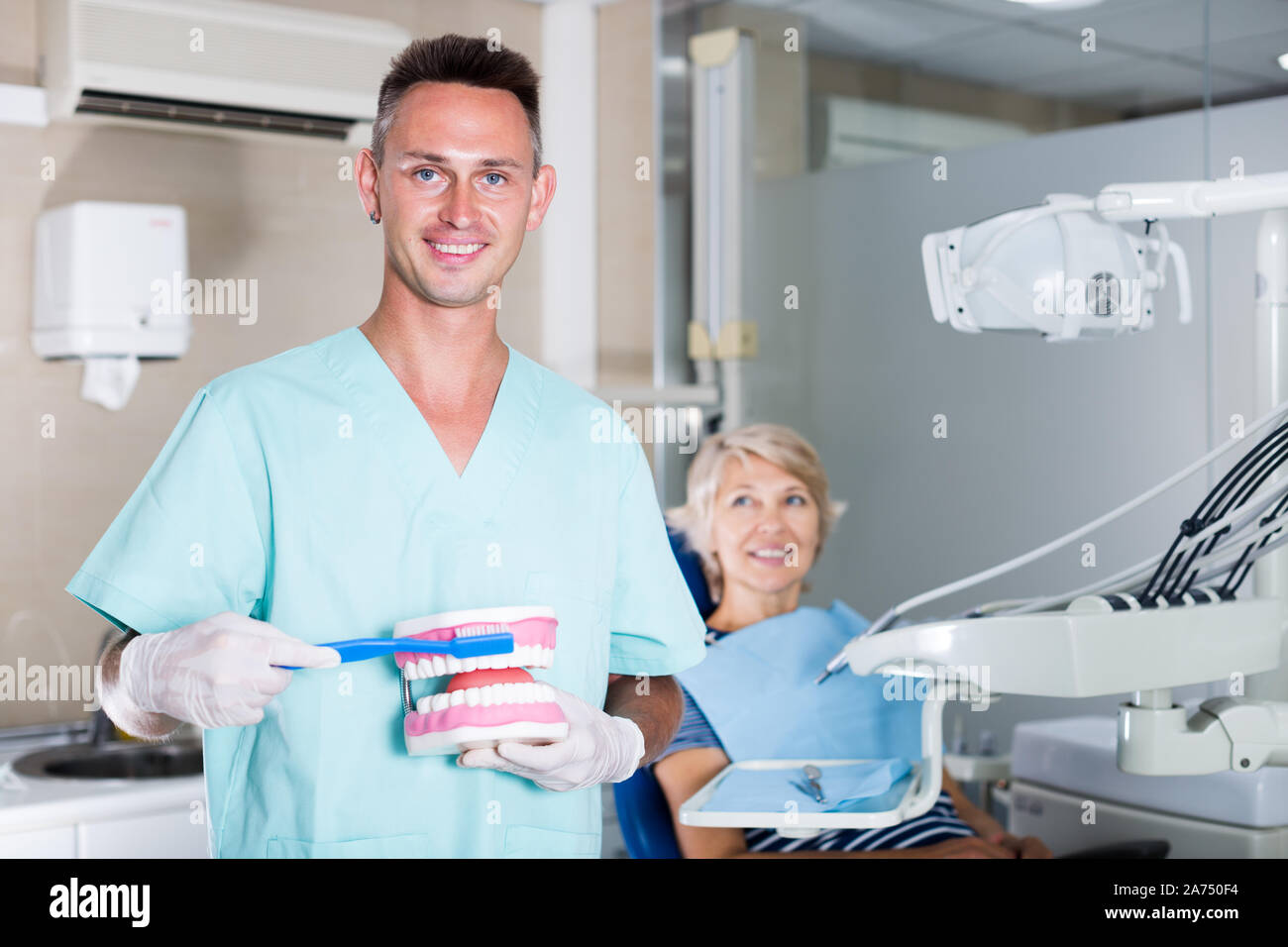 Dentist explaining how properly brush your teeth on dental model Stock ...