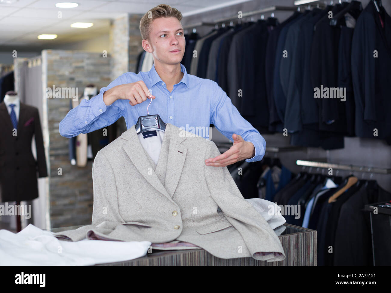 Portrait of man offering business style jacket in the shop Stock Photo ...