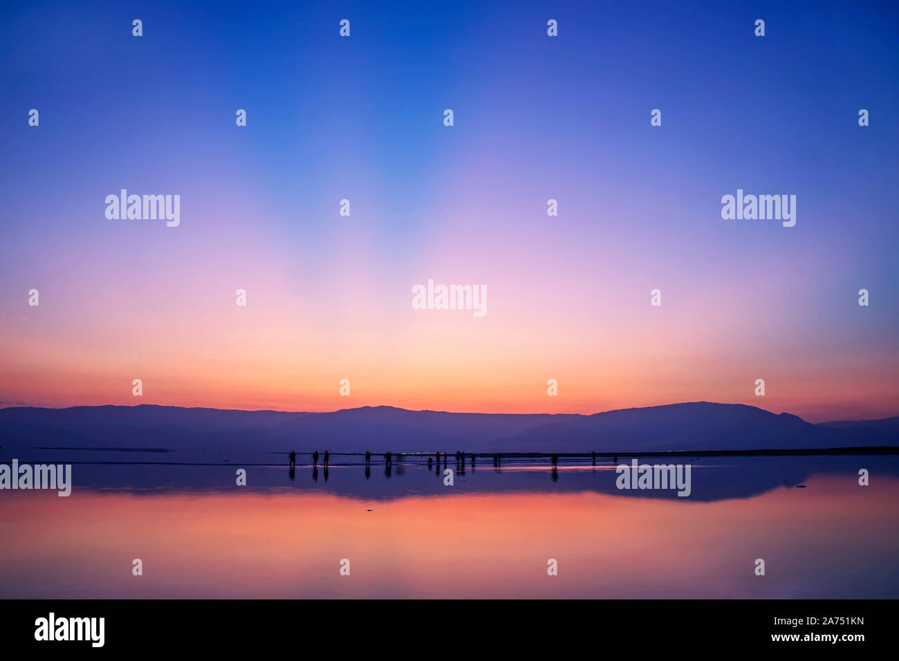 A group of photographers taking pictures of sunrise on the shore of the ...