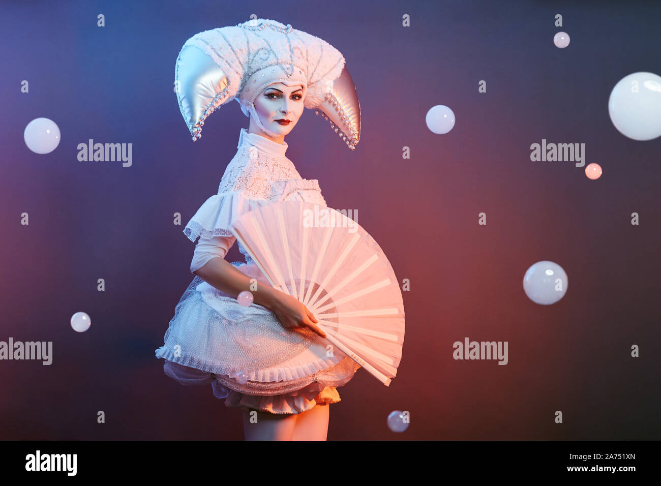 Circus performer magician shows tricks with soap bubbles. A woman and a ...