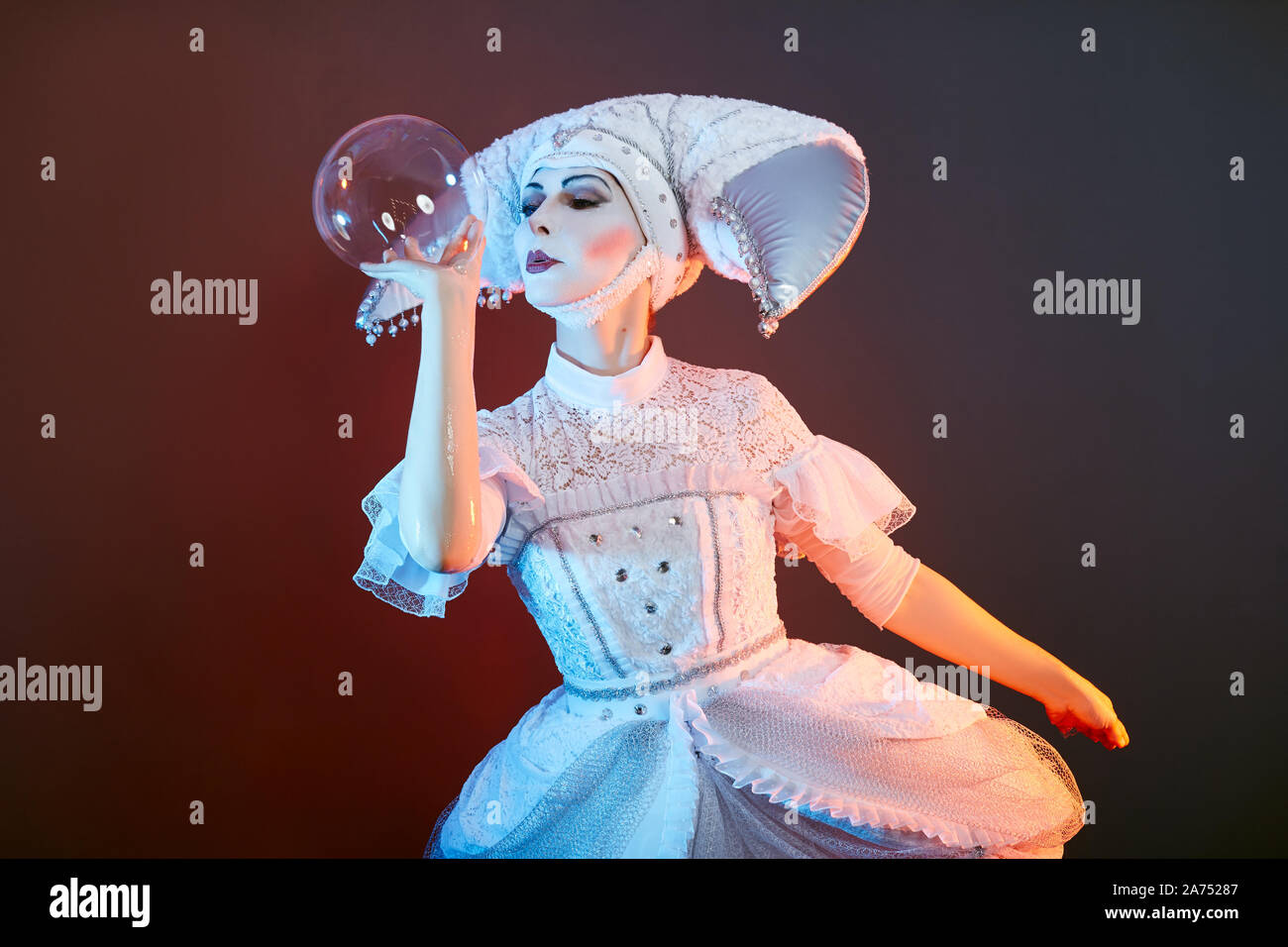 Circus performer magician shows tricks with soap bubbles. A woman and a ...