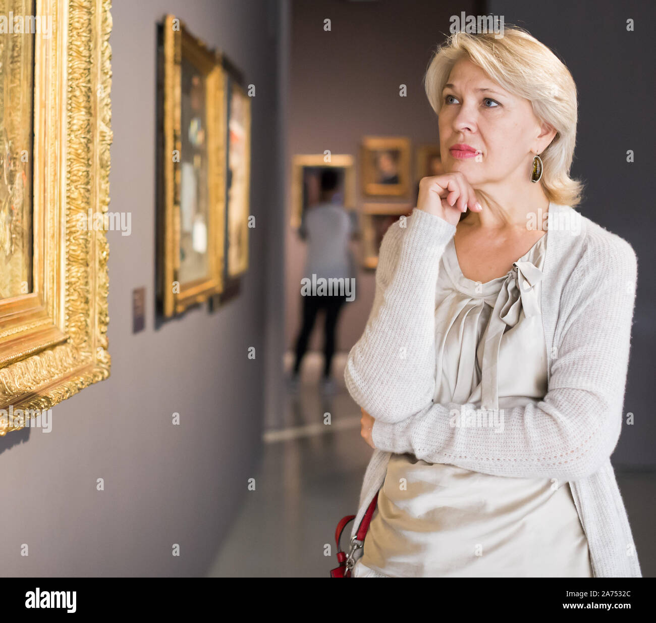 Portrait of adult woman near picture collection in the museum Stock ...