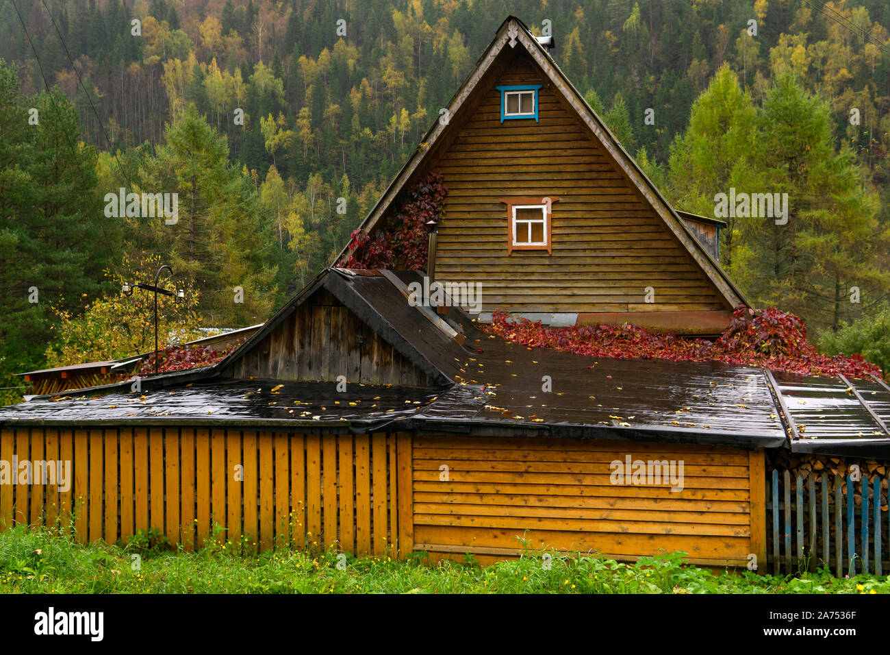 rustic wooden house with covered courtyard in the rain against the ...