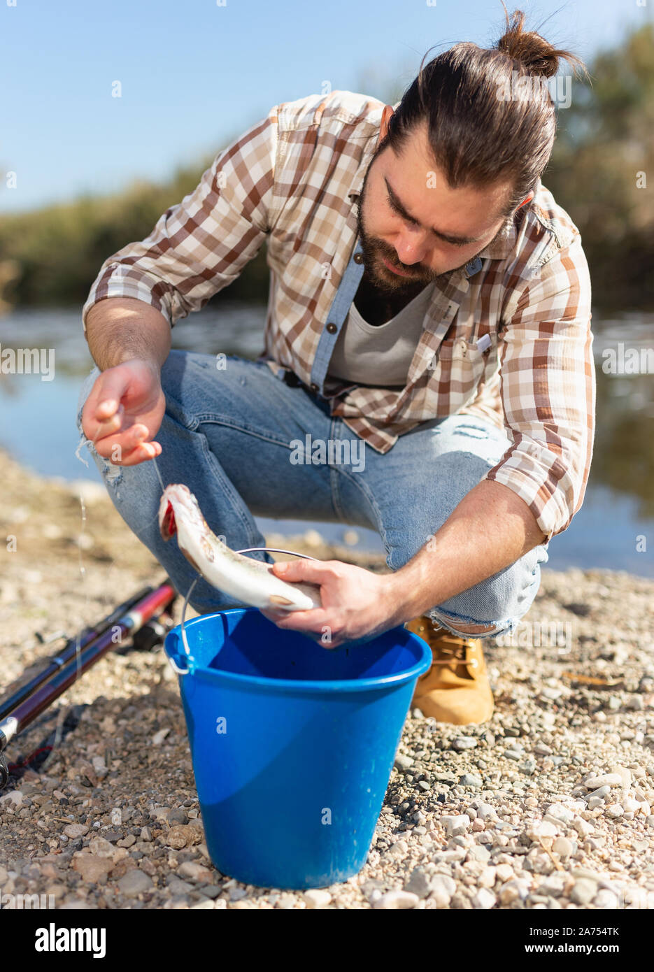 Adult male fisherman holding fish in his hands Stock Photo - Alamy