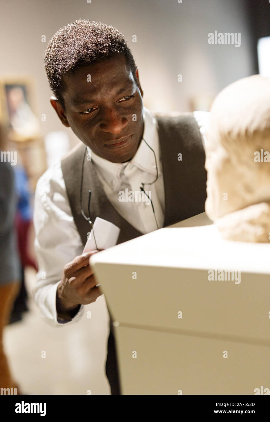 African man looking at exhibit on exposition of historical museum Stock ...