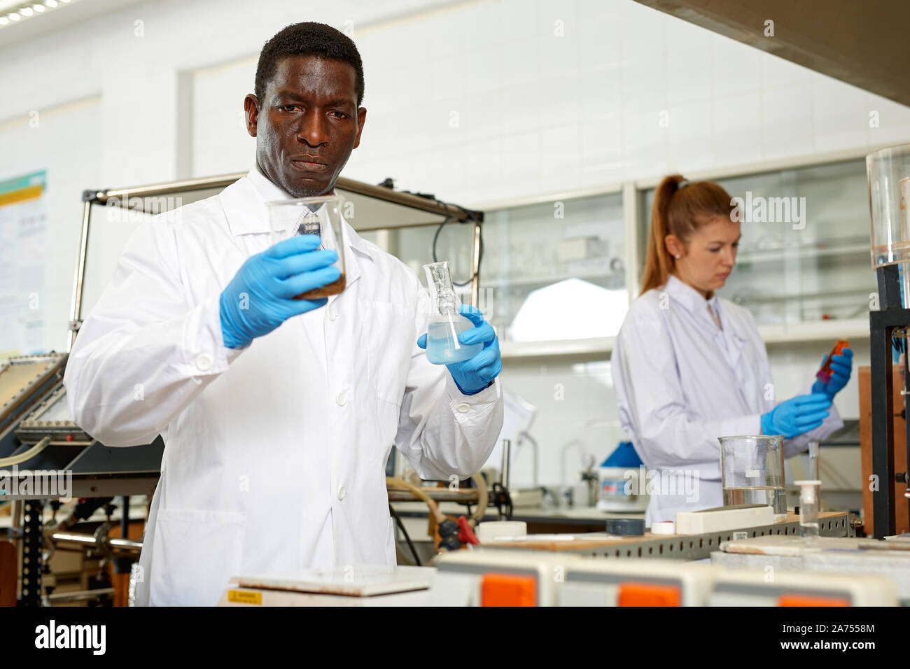 Serious male scientists with glass test tubes during chemical ...