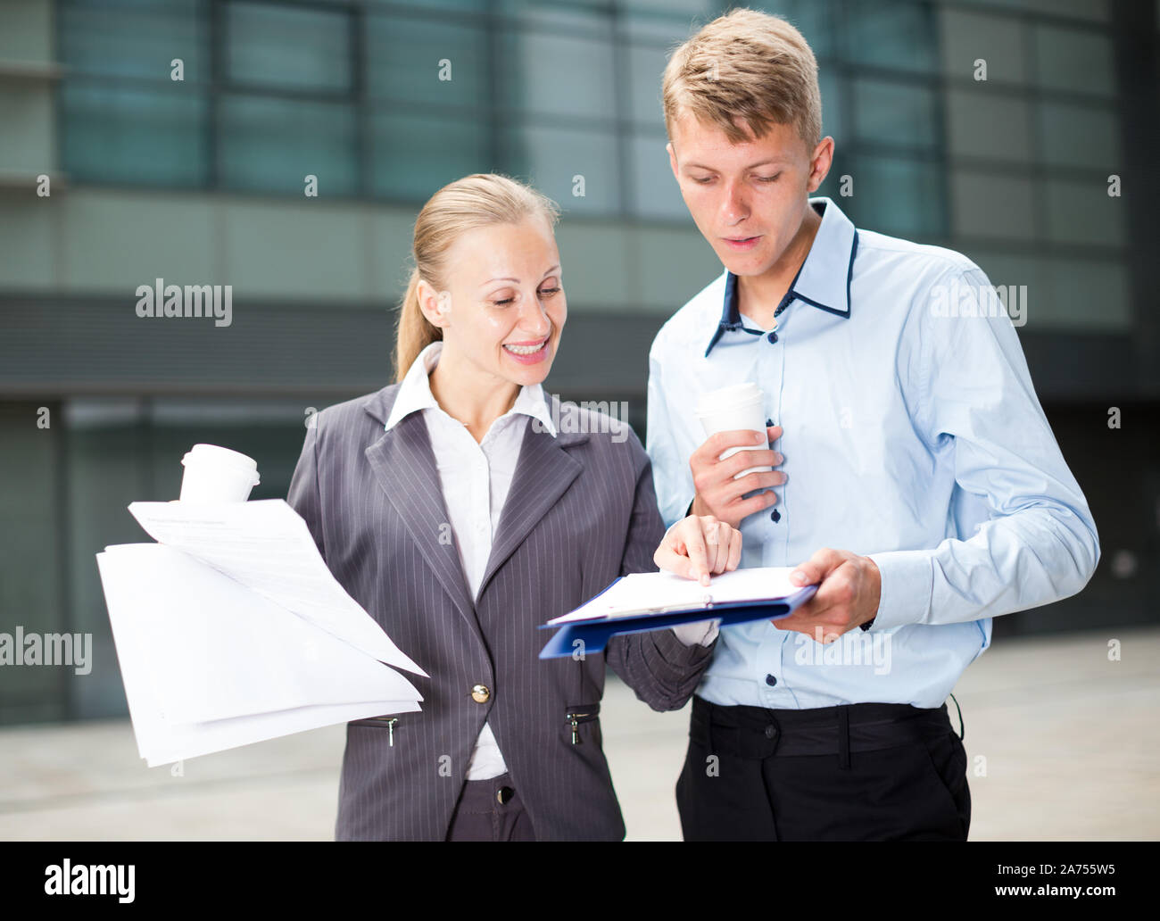 Businesswoman with her employee are reading documents before signing ...