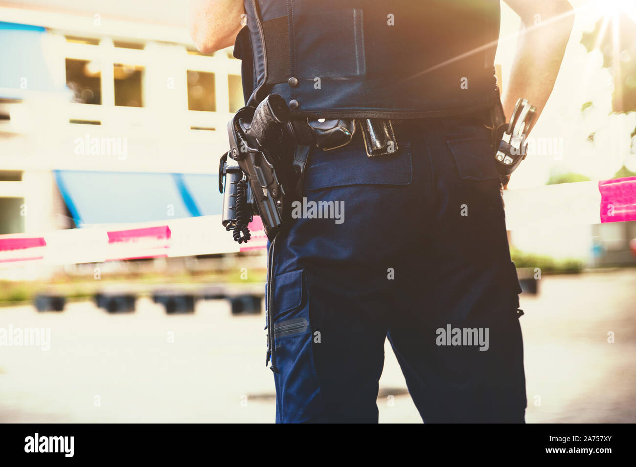 Policeman on crime scene . Red plastic tape and police officer, gun ...