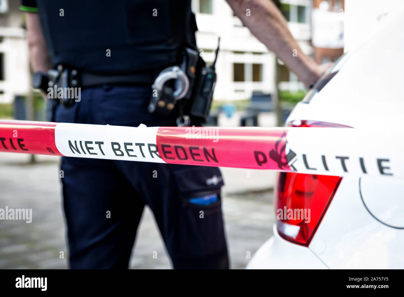 Dutch Policeman on crime scene at school. Red plastic tape police ...