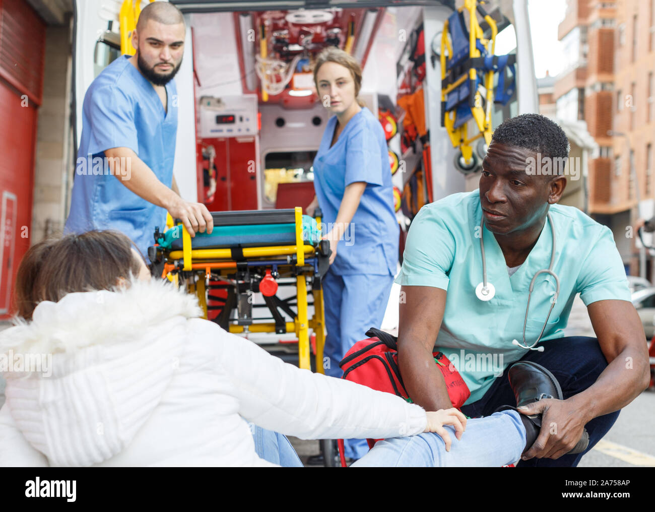 Paramedic team providing first aid to woman with injured leg Stock ...