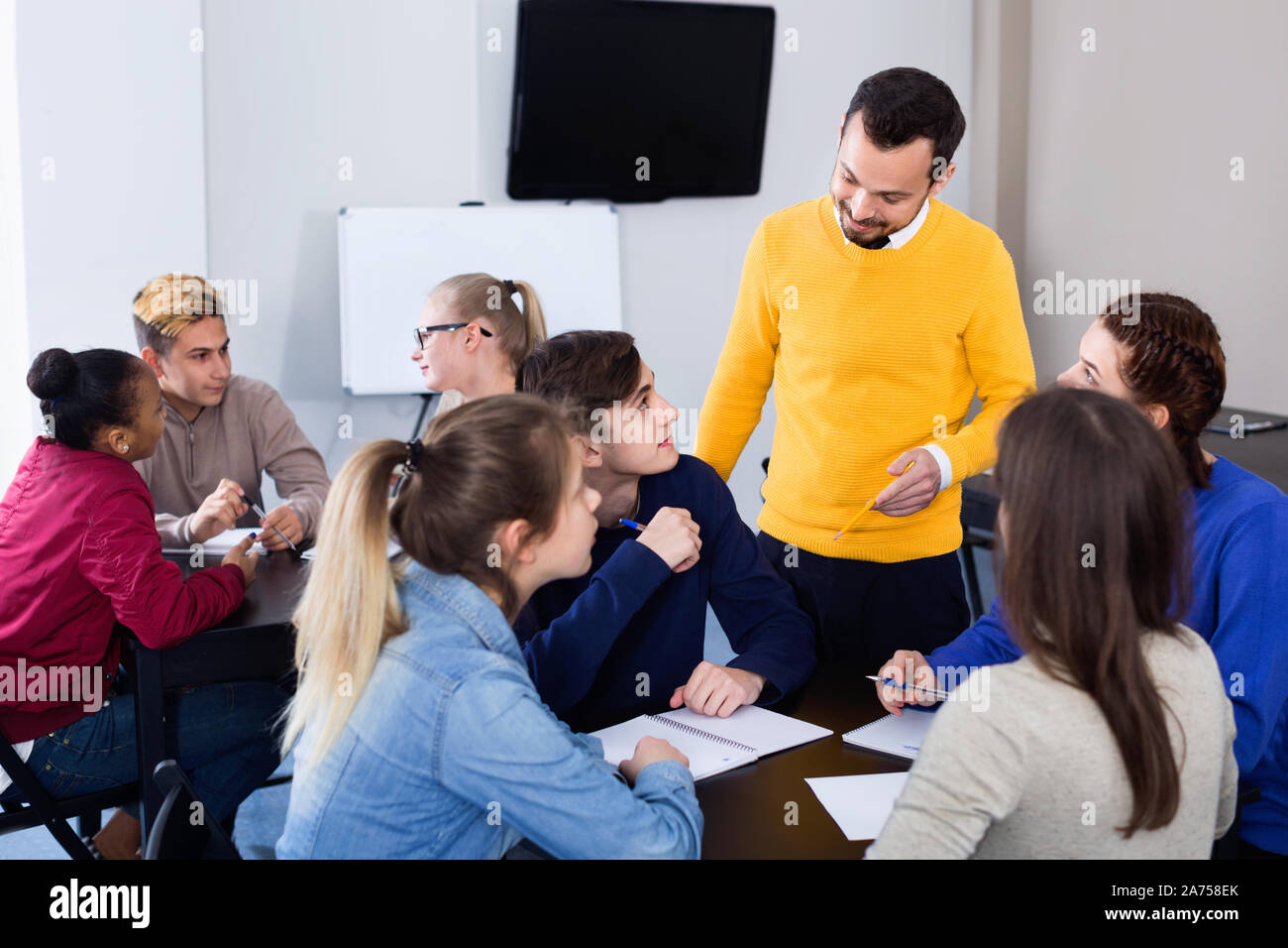 Glad positive fellow students having group work tasks during school day ...