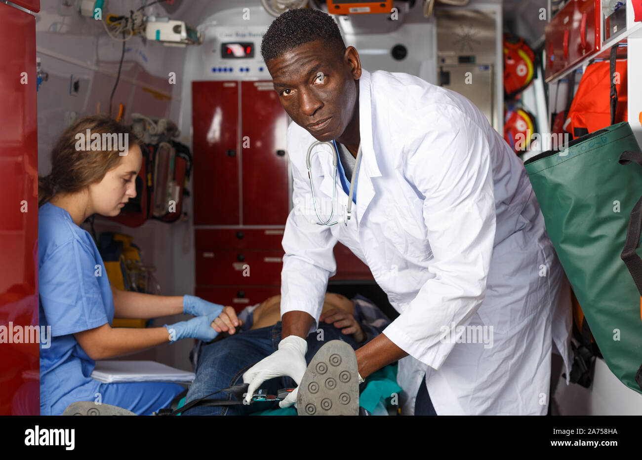 Ambulance team laying patient on stretcher in ambulance car Stock Photo ...