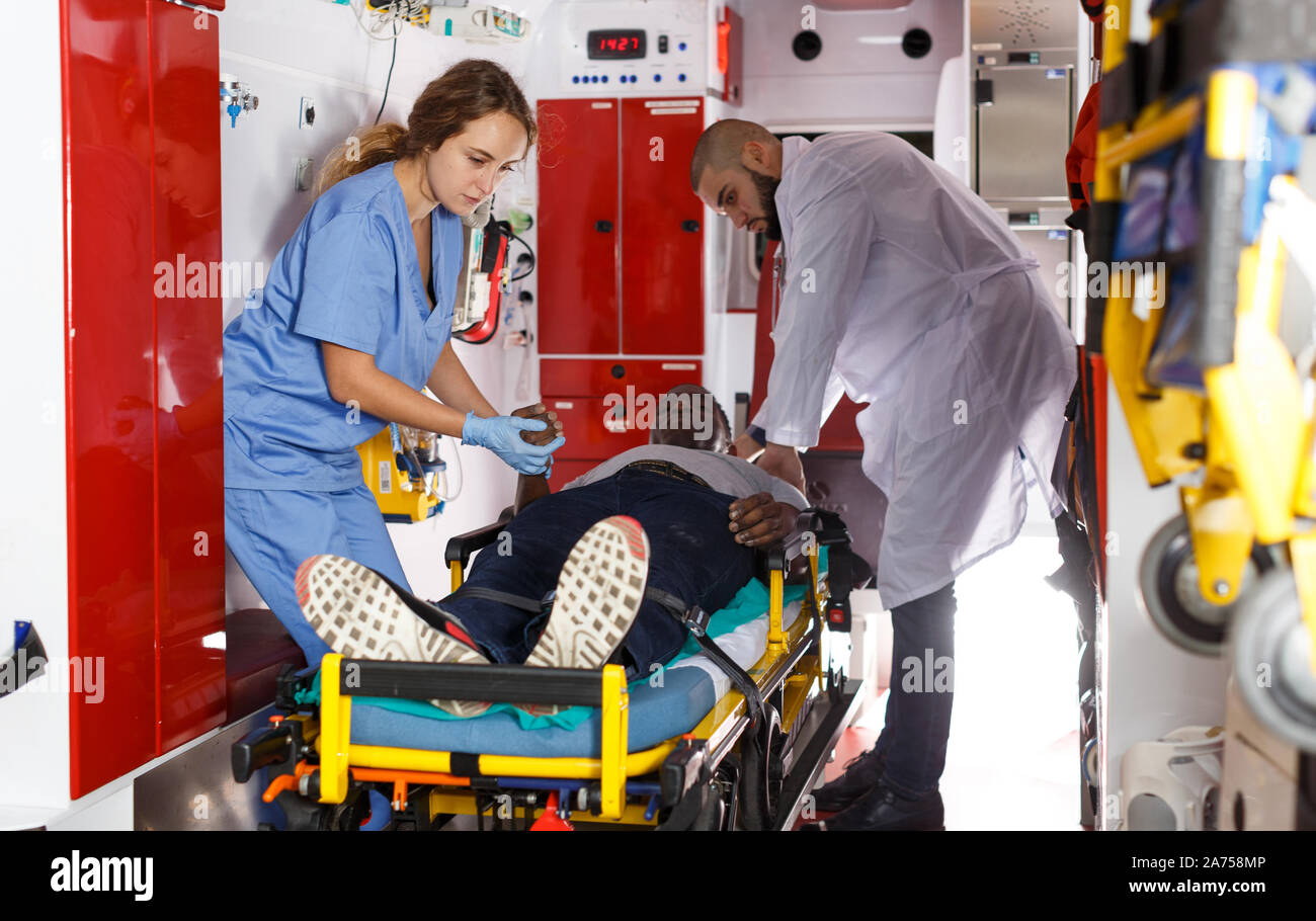 Ambulance team providing medical care to patient on stretcher in ...