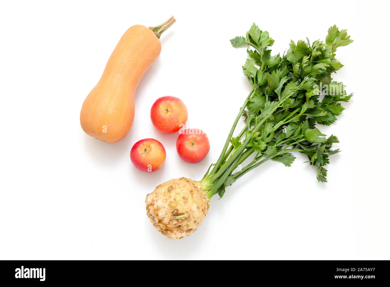 Pumpkin, apples and celery root and stem on a white background ...