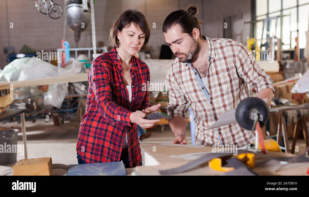 Team of aircraft enthusiasts working in workshop on creating of ...