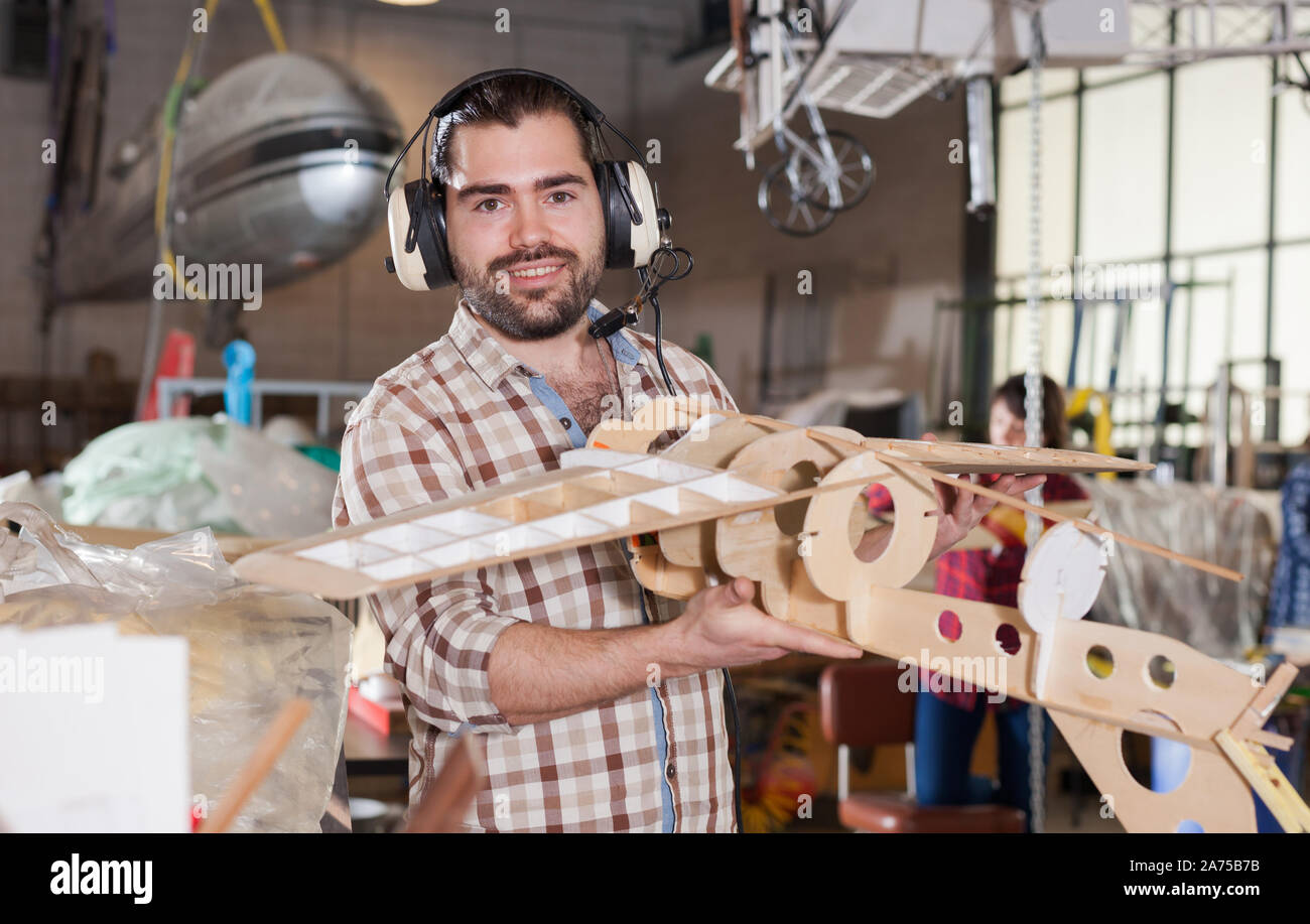 Smiling young man in pilot aviation headsets having fun with light ...