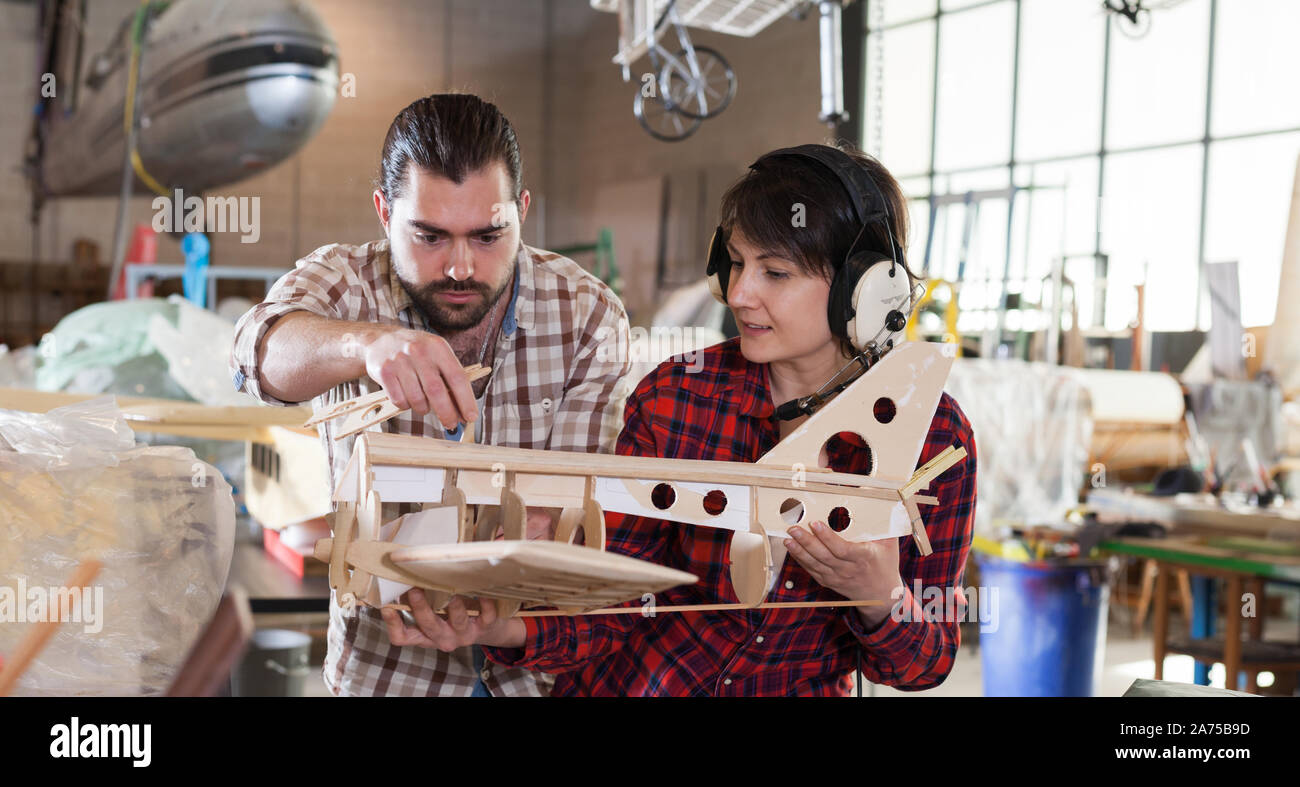 Team of aircraft enthusiasts working in workshop on creating of ...