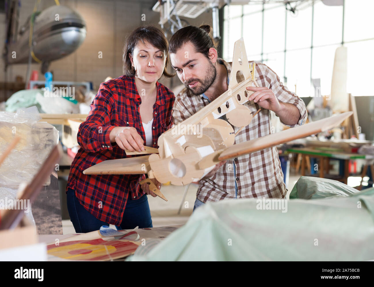 Team of aircraft enthusiasts working in workshop on creating of ...