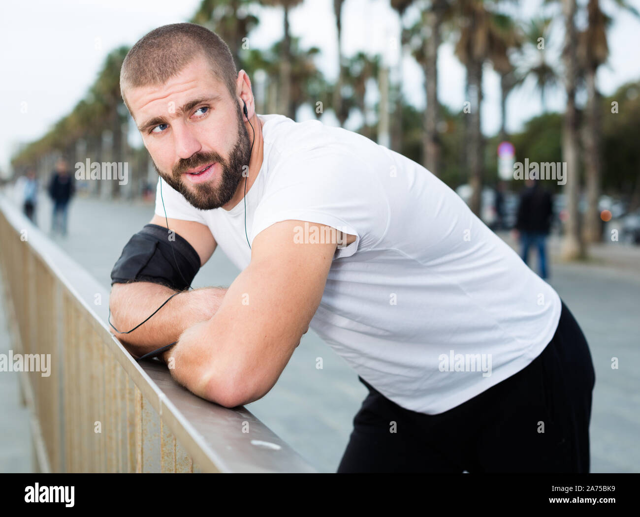 Athletic male stopped to rest while running Stock Photo - Alamy